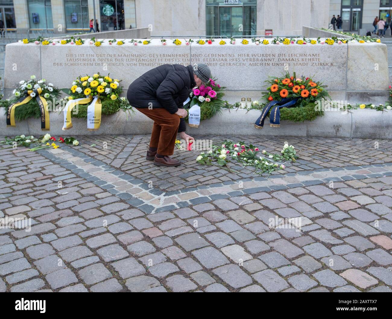Dresden, Germany. 13th Feb, 2020. A man places a grave light on the ...