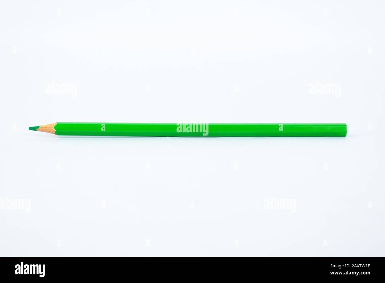 A Single green sharp wood pencil placed on an isolated white background ...