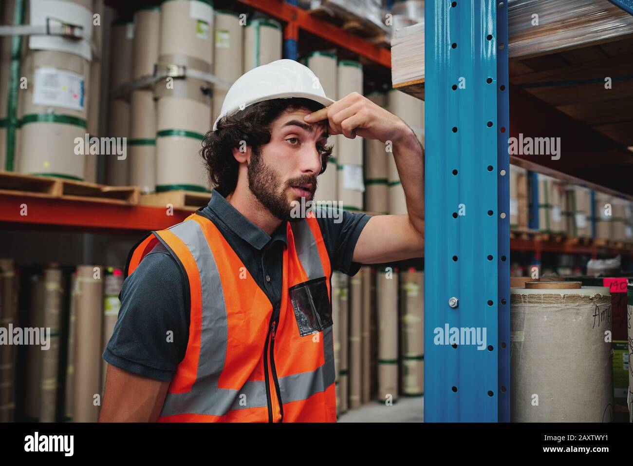 Young caucasian bearded worker wearing hardhat and safety jacket ...