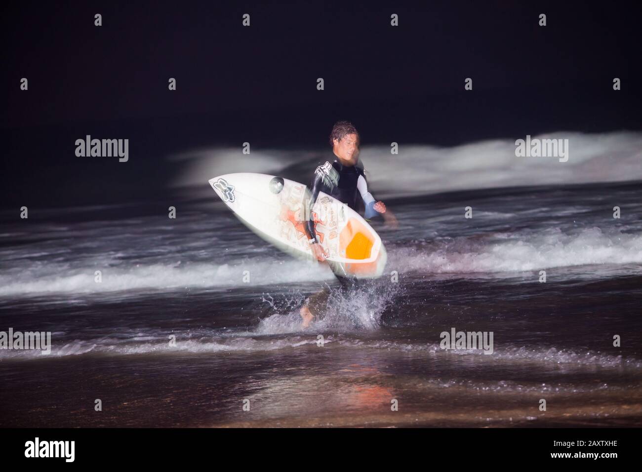 Surfer coming out of the sea after surfing with neon surfboards at ...