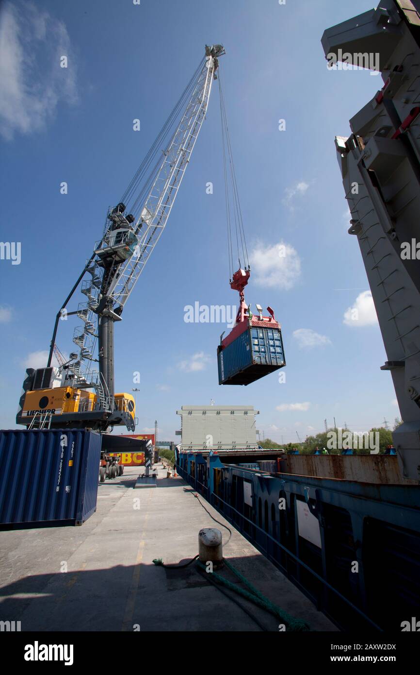 Liebherr Crane loading containers into cargo ship. Unloading from the ...