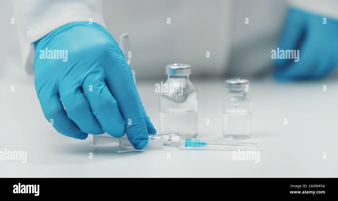 Hand putting syringe on table Stock Photo - Alamy