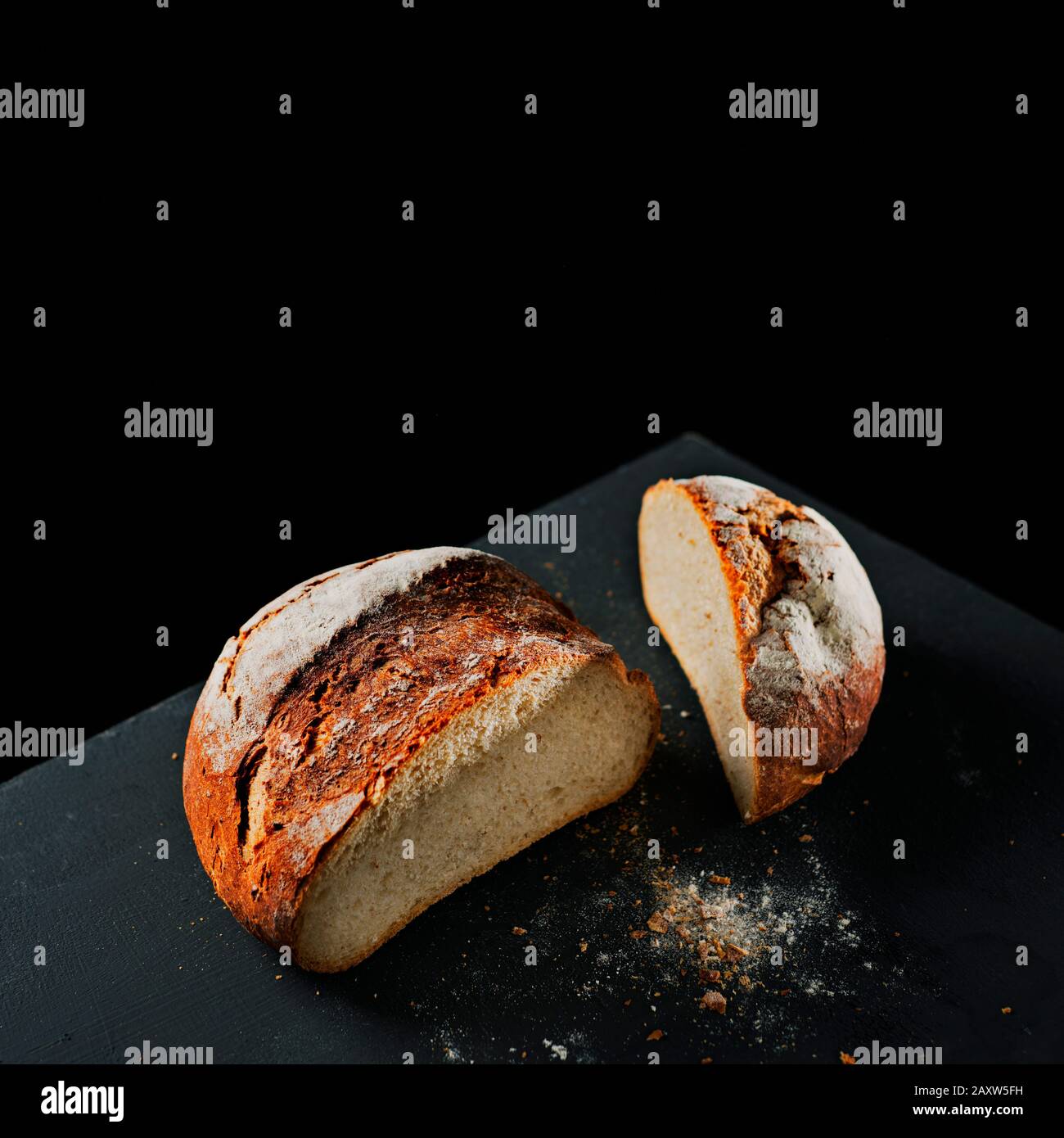 a pan de payes, a round bread typical of Catalonia, Spain, on a dark ...