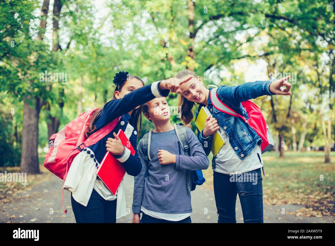 Back to school. Close up three happy friends with backpacks laughing ...