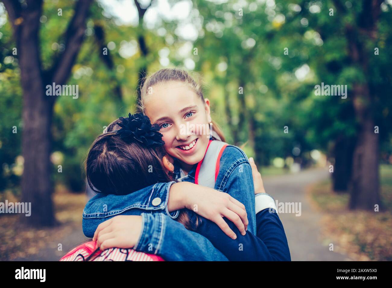 Two school friends hugging, emotional meeting in the park.. The concept ...