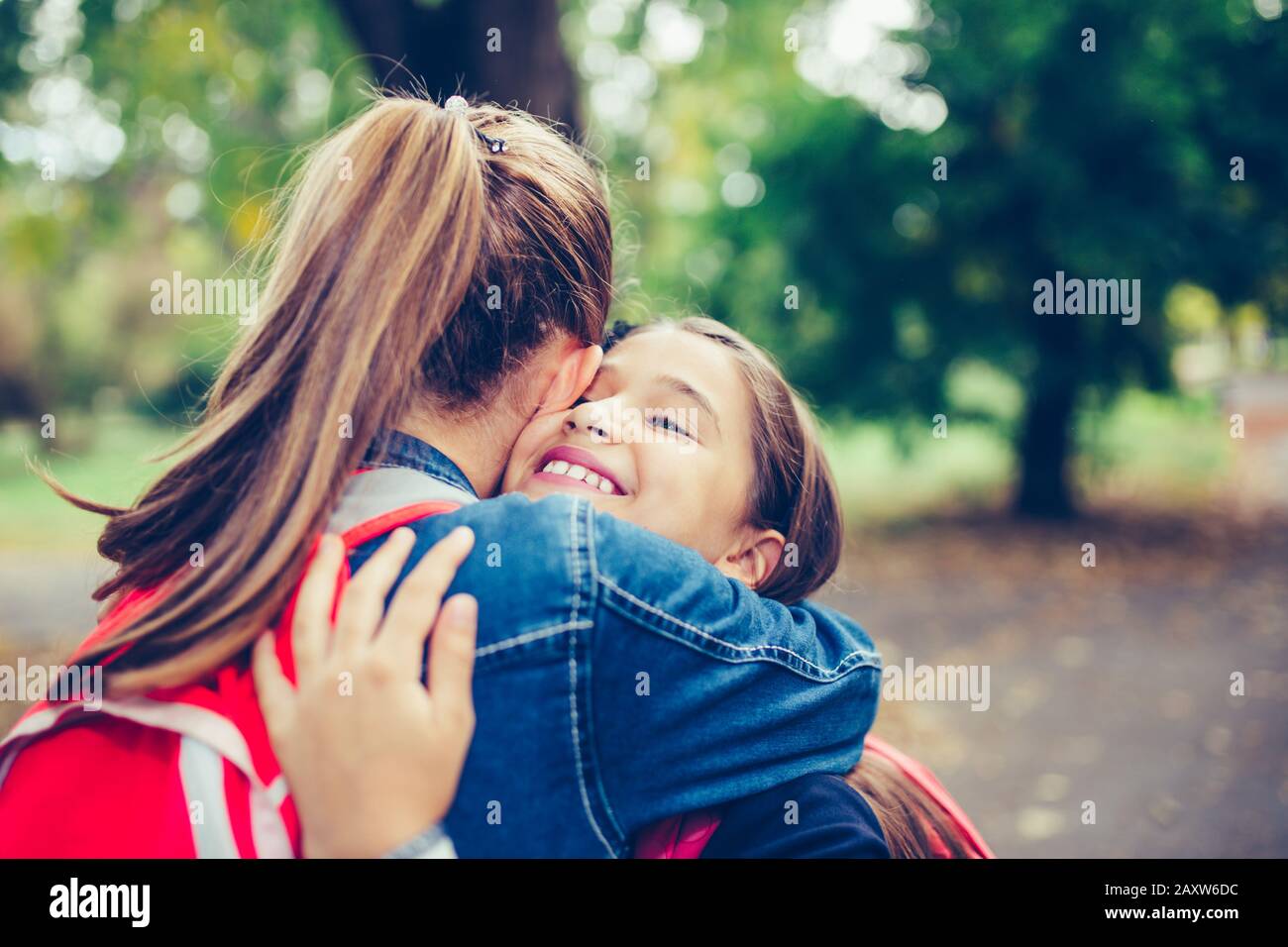 Two school friends hugging, emotional meeting in the park. The concept ...