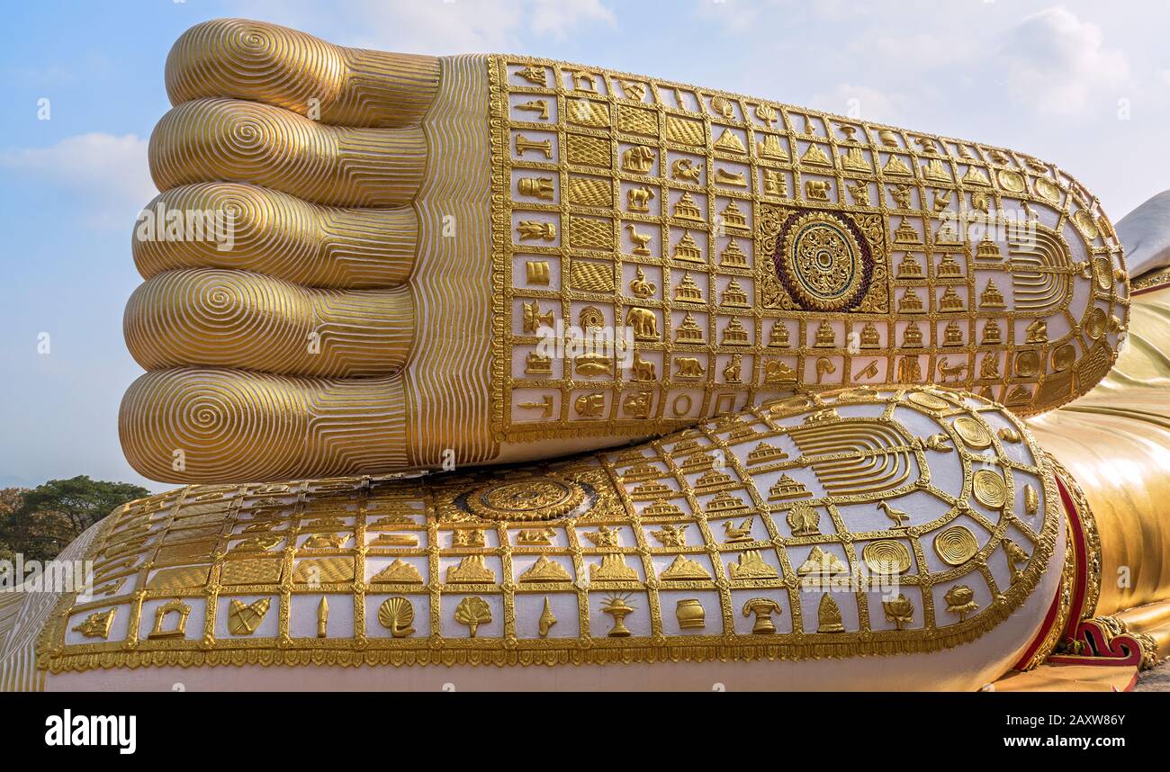Feet of Giant Buddha statue in the Buddhist temple in the morning light ...