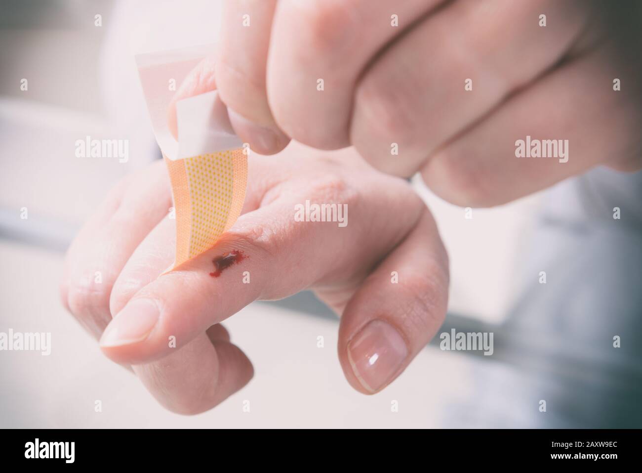 Applying adhesive bandage on bleeding finger Stock Photo - Alamy