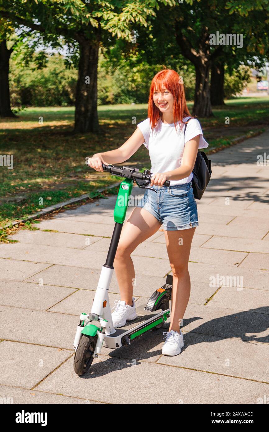 Woman riding electric scooter through hi-res stock photography and ...