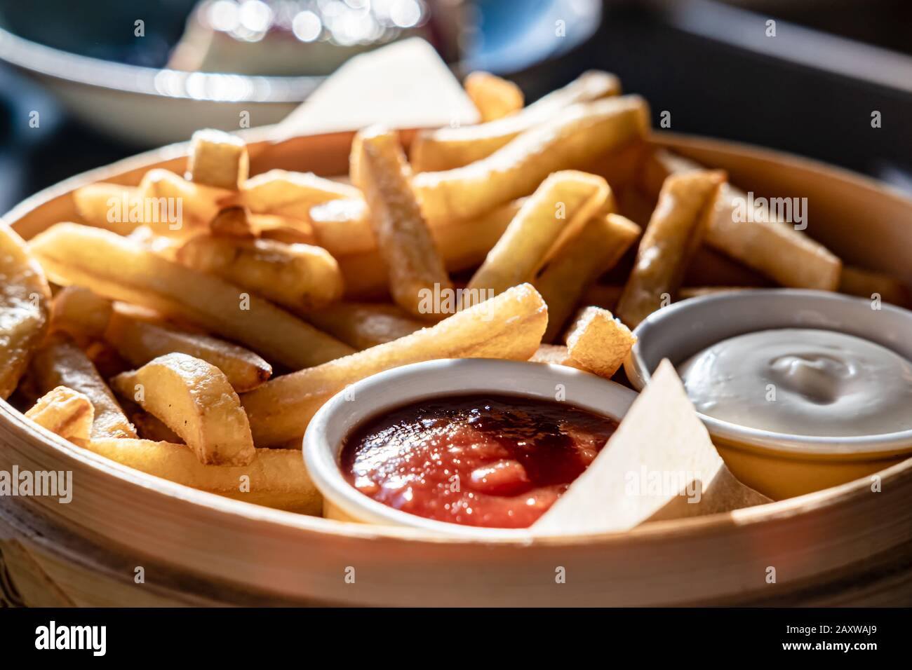 French fries with sauce in a wooden dish, in natural light from the ...