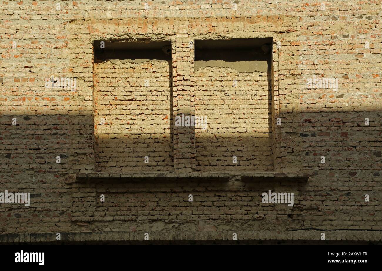 Brick facade without plaster with two brick-built windows. Restoration ...