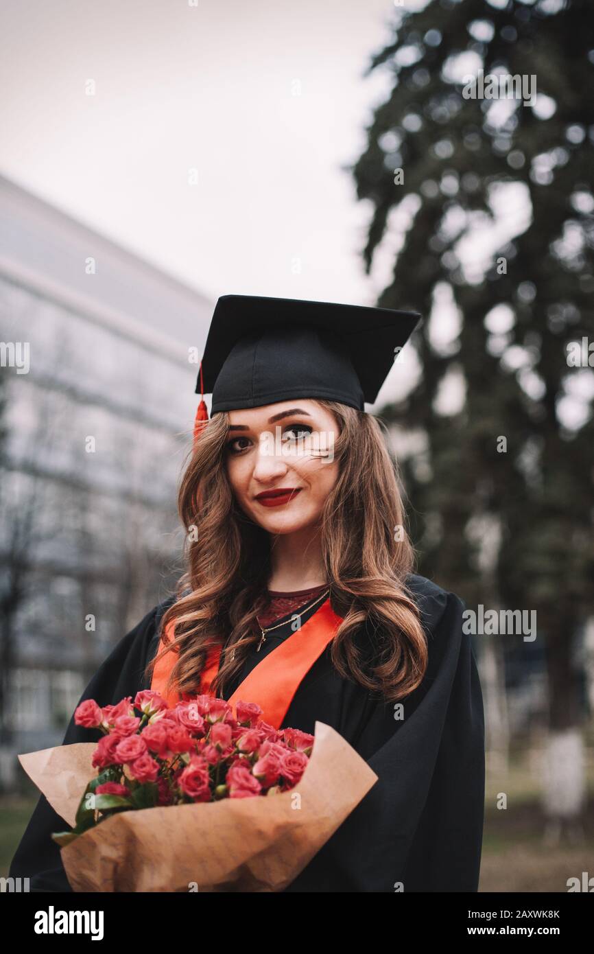 Graduate holding bouquet flowers graduation hi-res stock photography ...