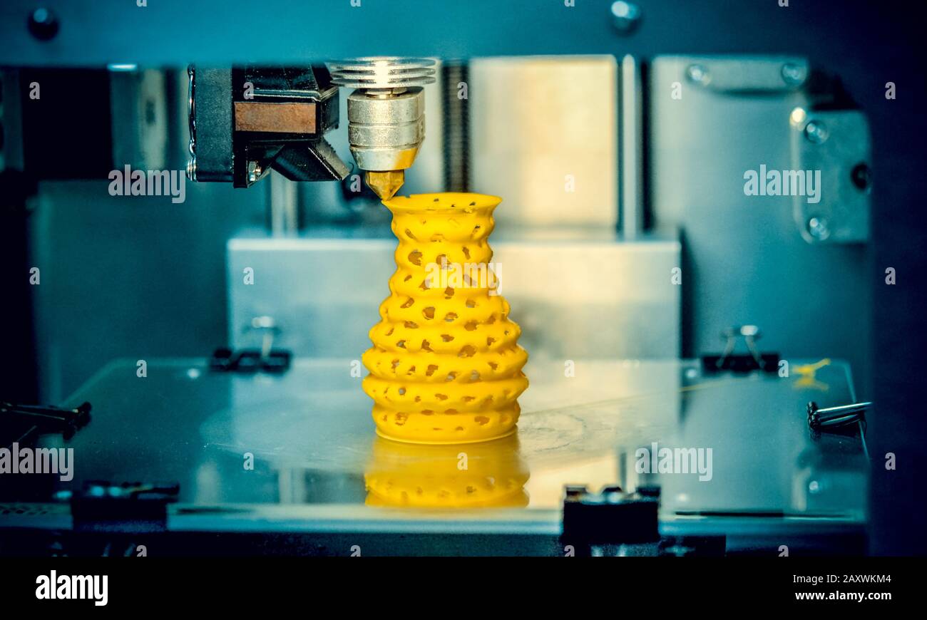 3D printer prints from the plastic figure closeup. 3D printer makes ...