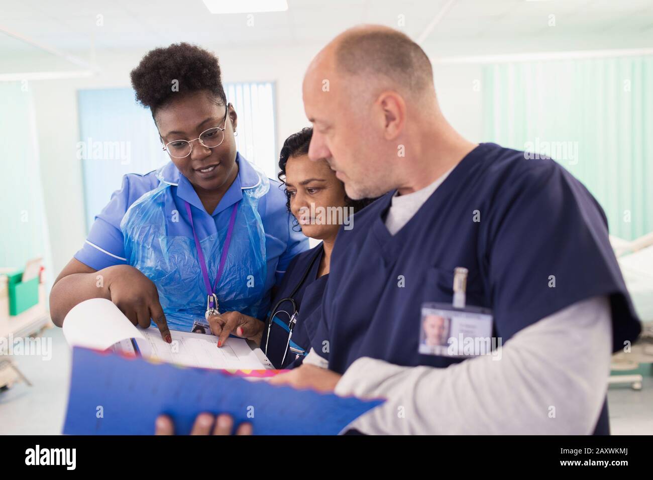 Doctors and nurse with medical chart making rounds, consulting in ...