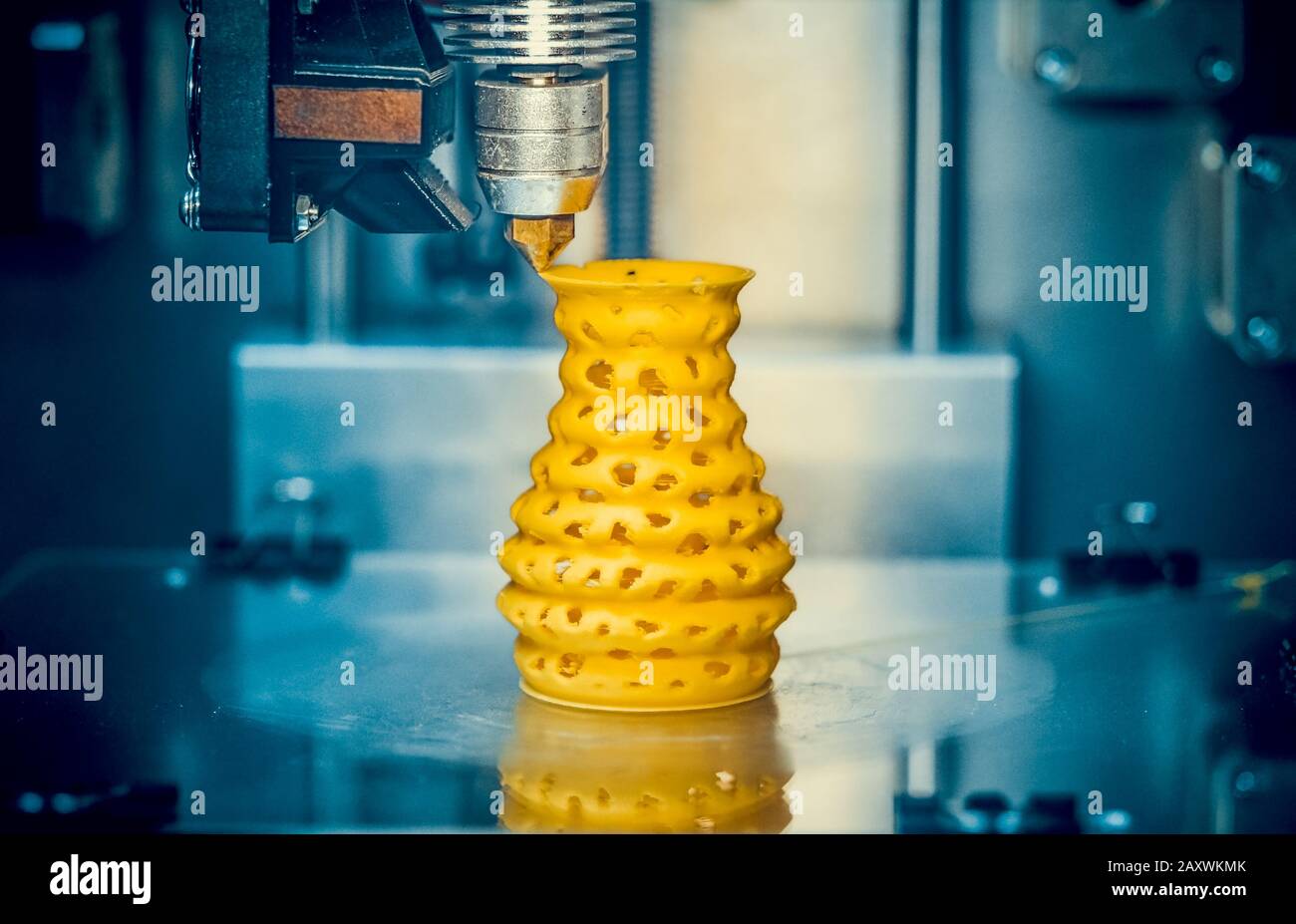 3D printer prints from the plastic figure closeup. 3D printer makes ...