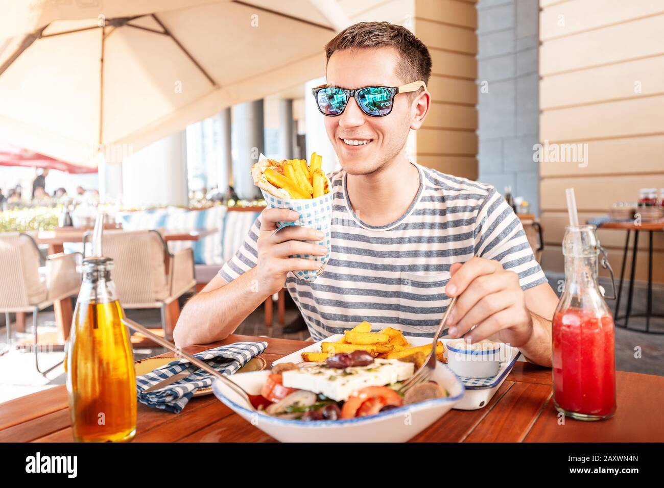 Cheerful man eating gyros pita in cafe. Middle eastern street food ...