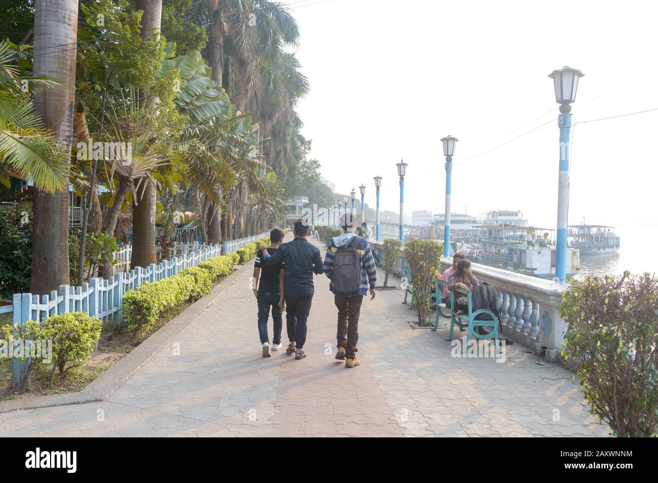 Friends walking along the promenade in street footpath on a quiet and ...