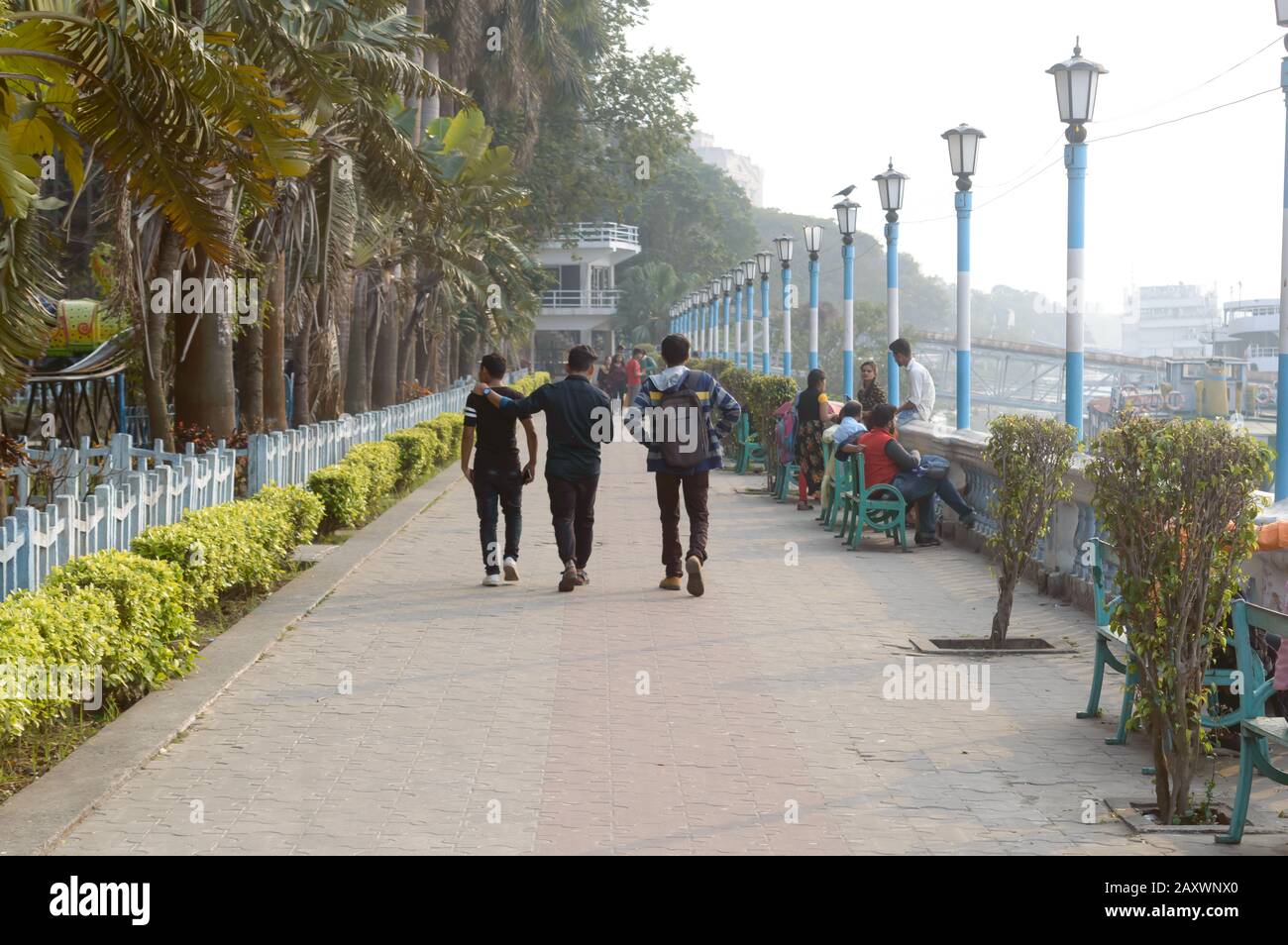 Friends walking along the promenade in street footpath on a quiet and ...
