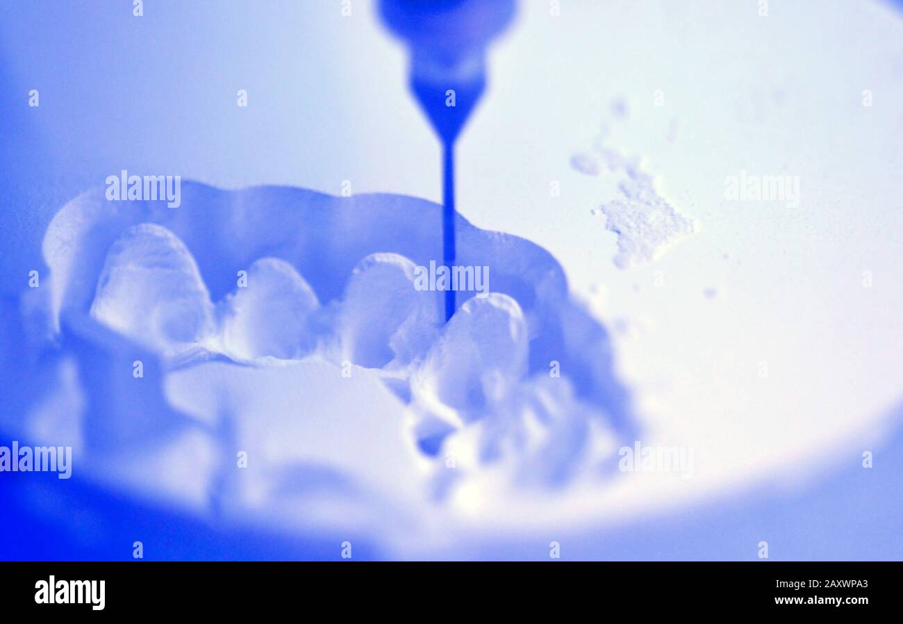 Dental milling machine carving out shape of human teeth close-up ...