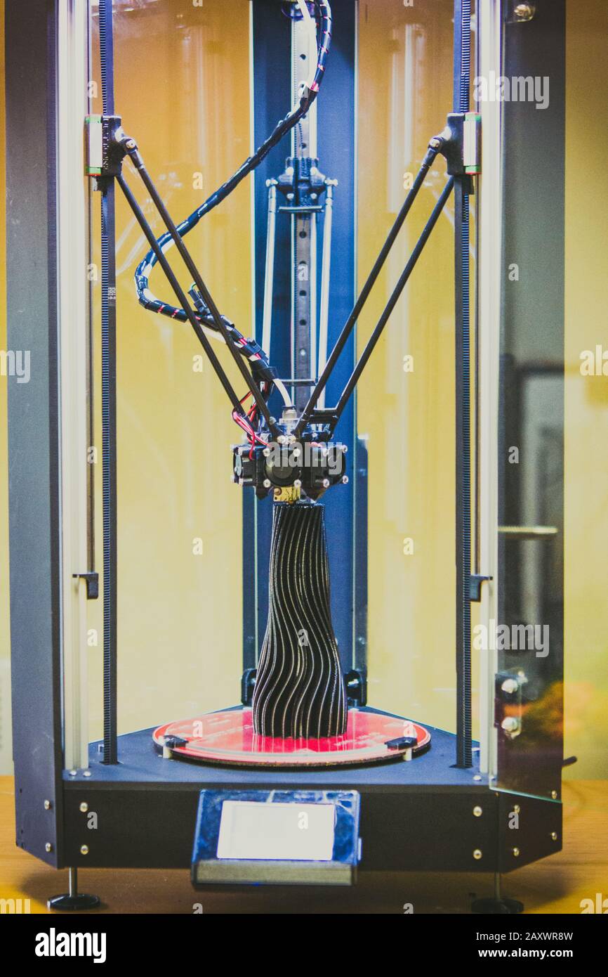 3d printer prints a model of a black vase close-up. Progressive modern ...