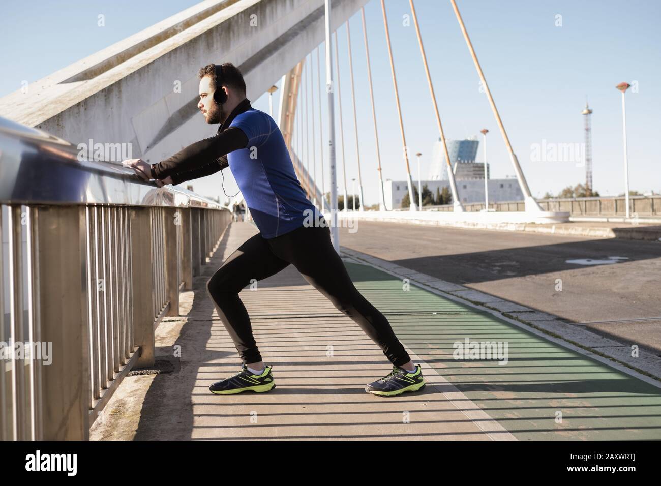 man stretching on a bridge railing. sport concept Stock Photo - Alamy