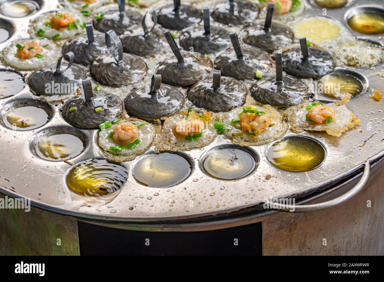 Sizzling mini pancake- Banh Khot at Vietnamese street food market Stock ...