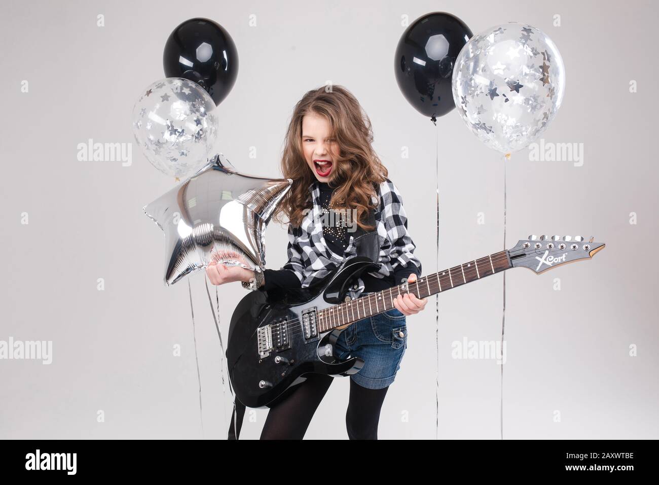 Cute baby girl rock star playing electric guitar and singing song ...