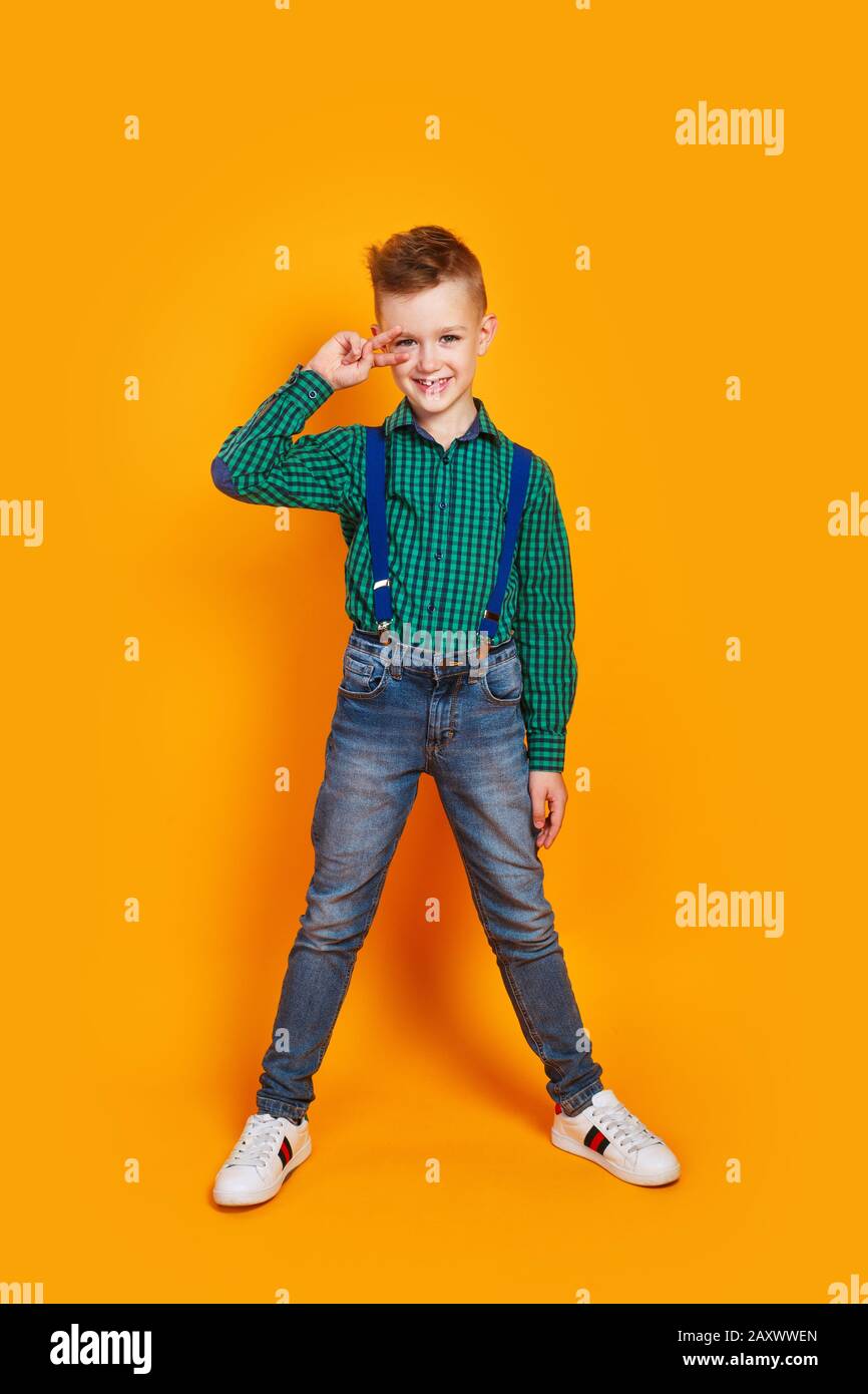 Happy smiling boy on a yellow background expresses emotions through ...