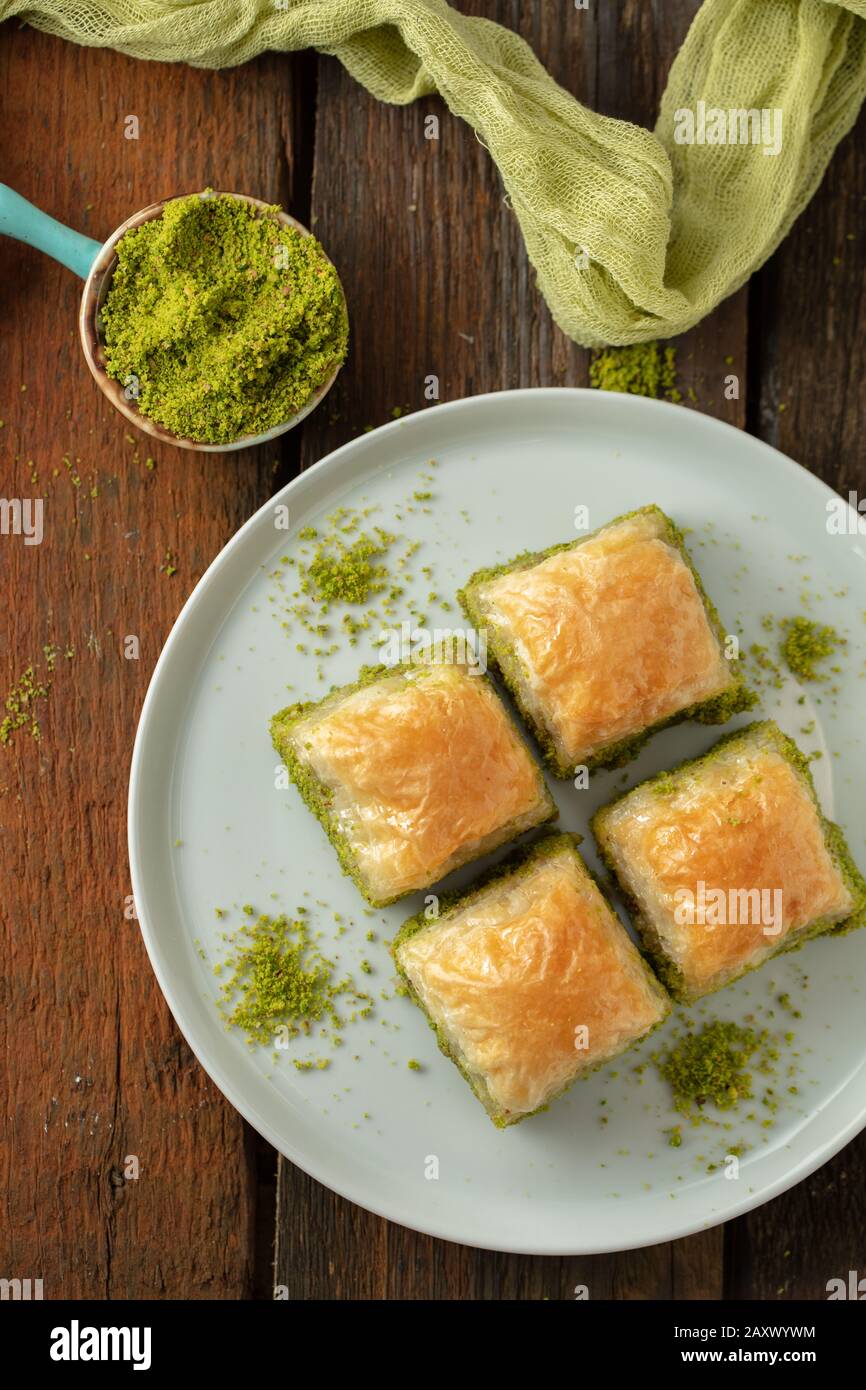 Vertical picture of baklava cut in cubes with raw pistachio topping in ...