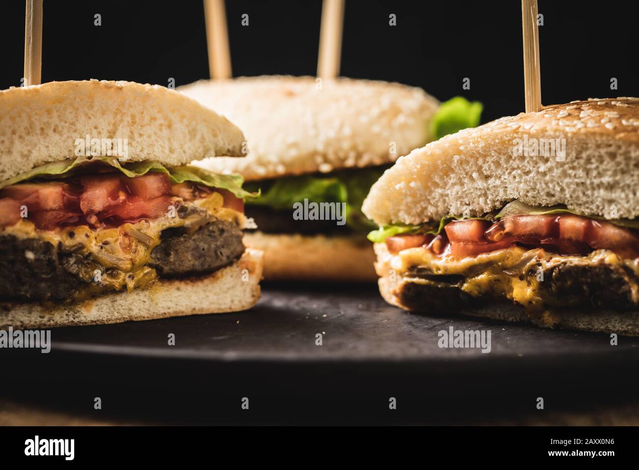 Beautiful shot of hamburgers sliced in half and pierced with sticks ...