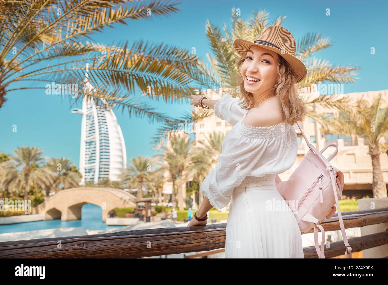 Cheerful Asian tourist girl with the famous Burj al Arab hotel building ...