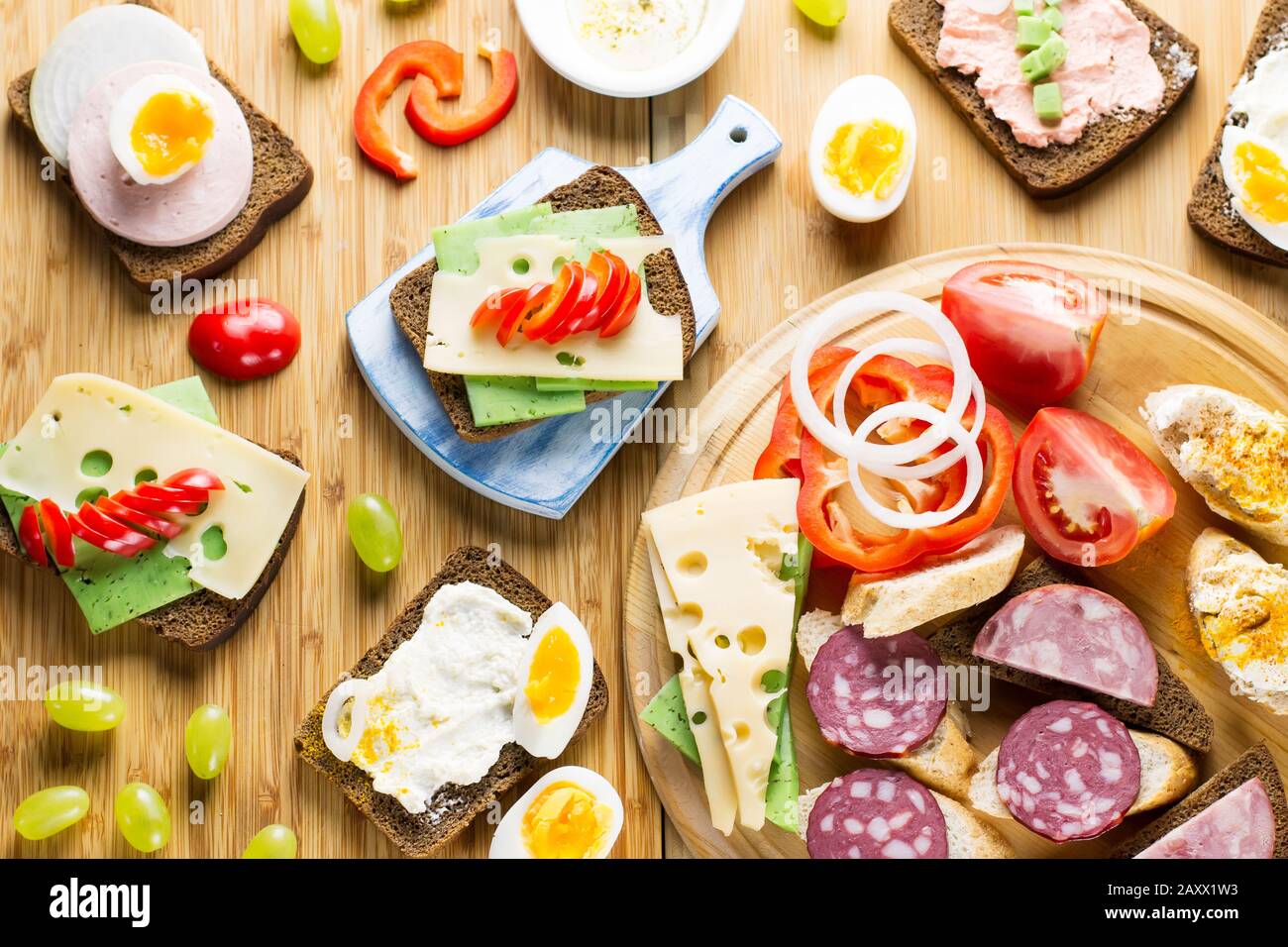 Breakfast table with cheese sandwiches, sausage, vegetables, hard ...