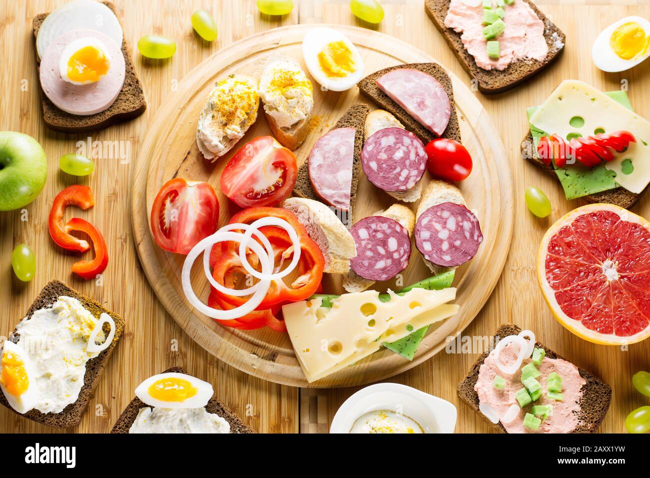 Breakfast table with cheese sandwiches, sausage, vegetables, hard ...