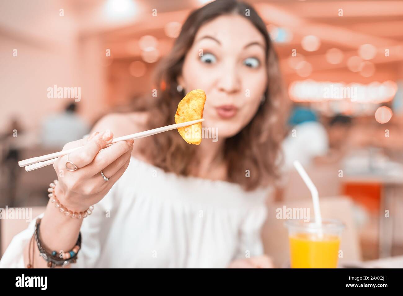 Asian girl eating Japanese Gyoza dumplings in food court during lunch ...