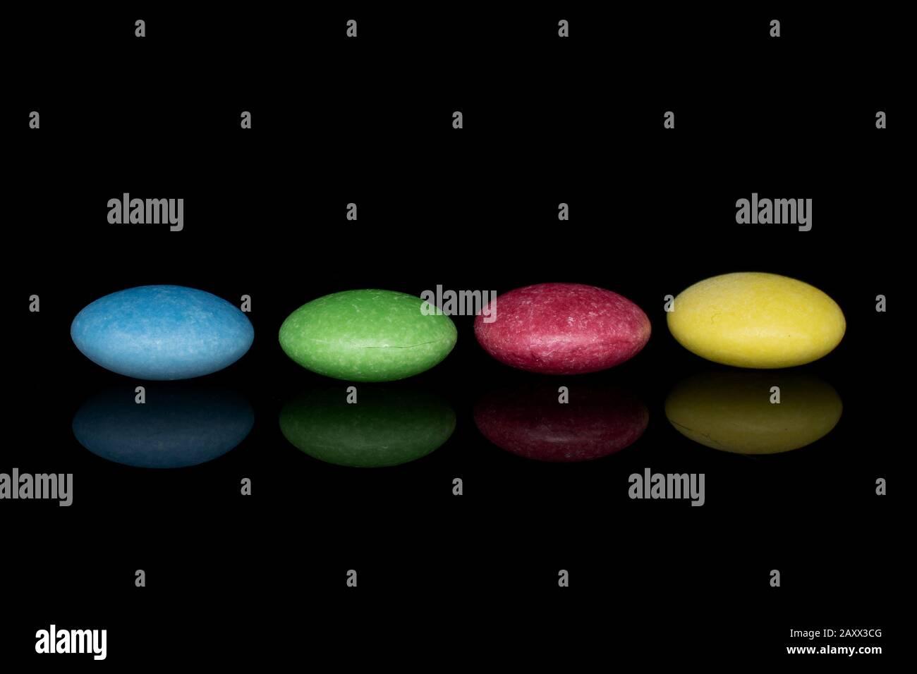 Group of four whole sweet colourful candy isolated on black glass Stock ...