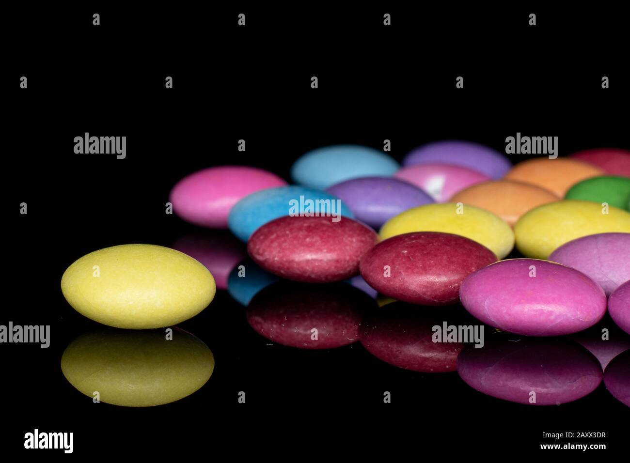 Lot of whole small sweet colourful candy isolated on black glass Stock ...