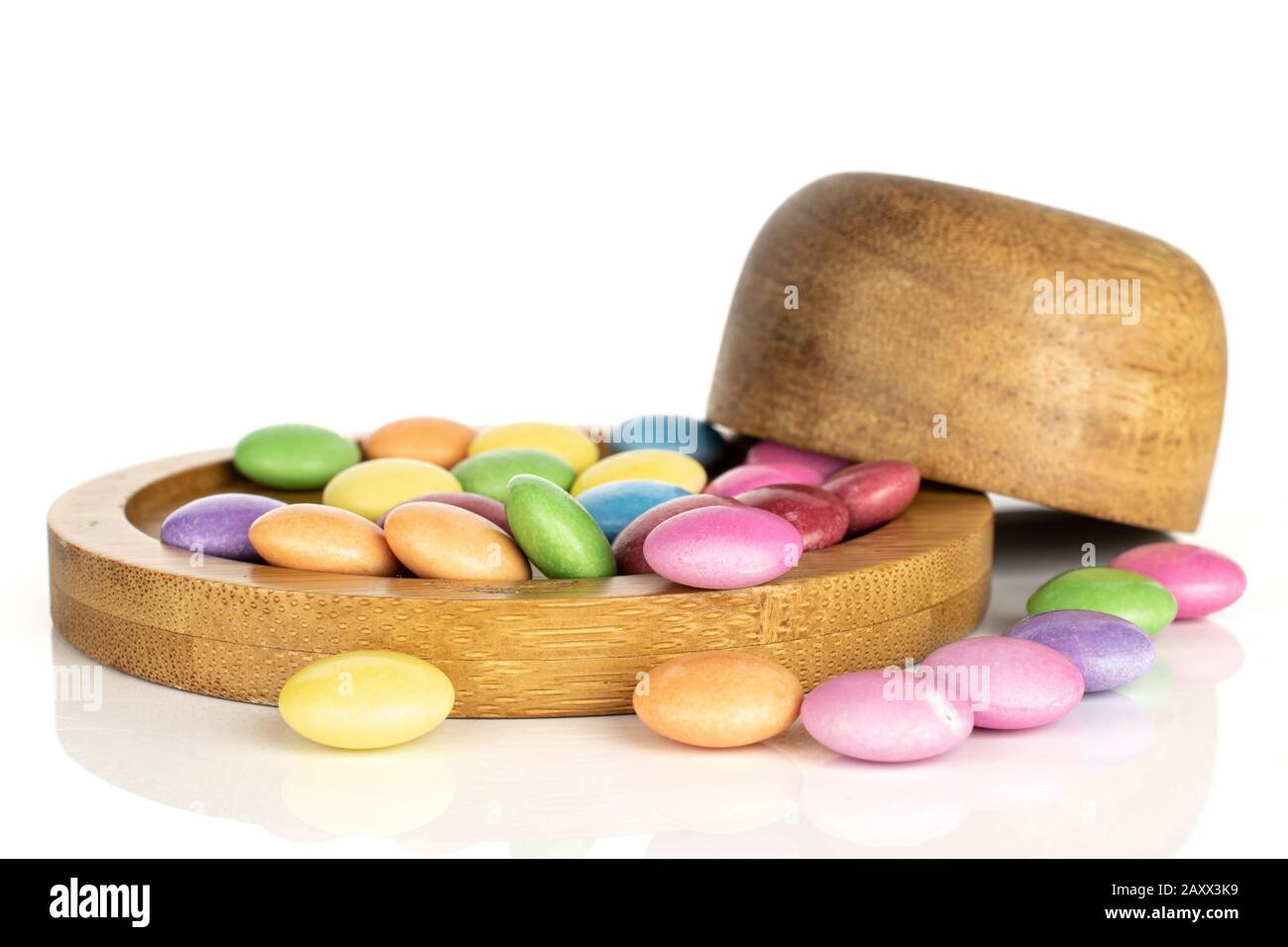 Lot of whole sweet colourful candy in bamboo bowl on round bamboo ...