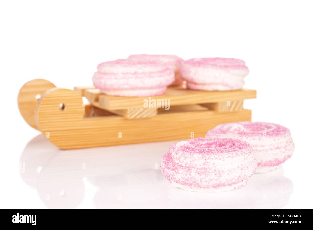 Group of five whole pink sweet meringue with wooden sledge isolated on ...