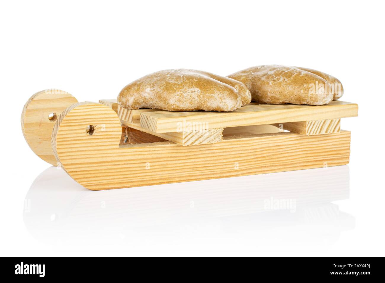 Group of two whole sweet brown gingerbread with wooden sledge isolated ...