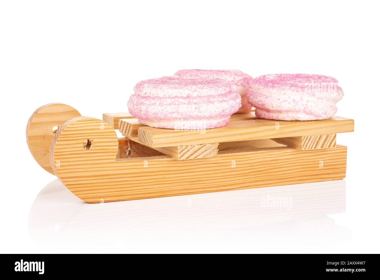Group of three whole pink sweet meringue with wooden sledge isolated on ...