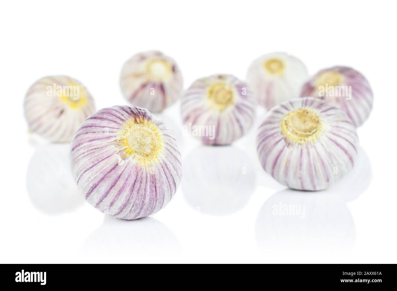 Group of seven whole fresh purple single clove garlic isolated on white ...