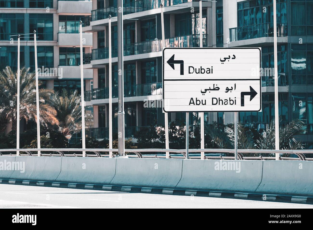 Road sign directions to Dubai and Abu Dhabi. Transport infrastructure ...