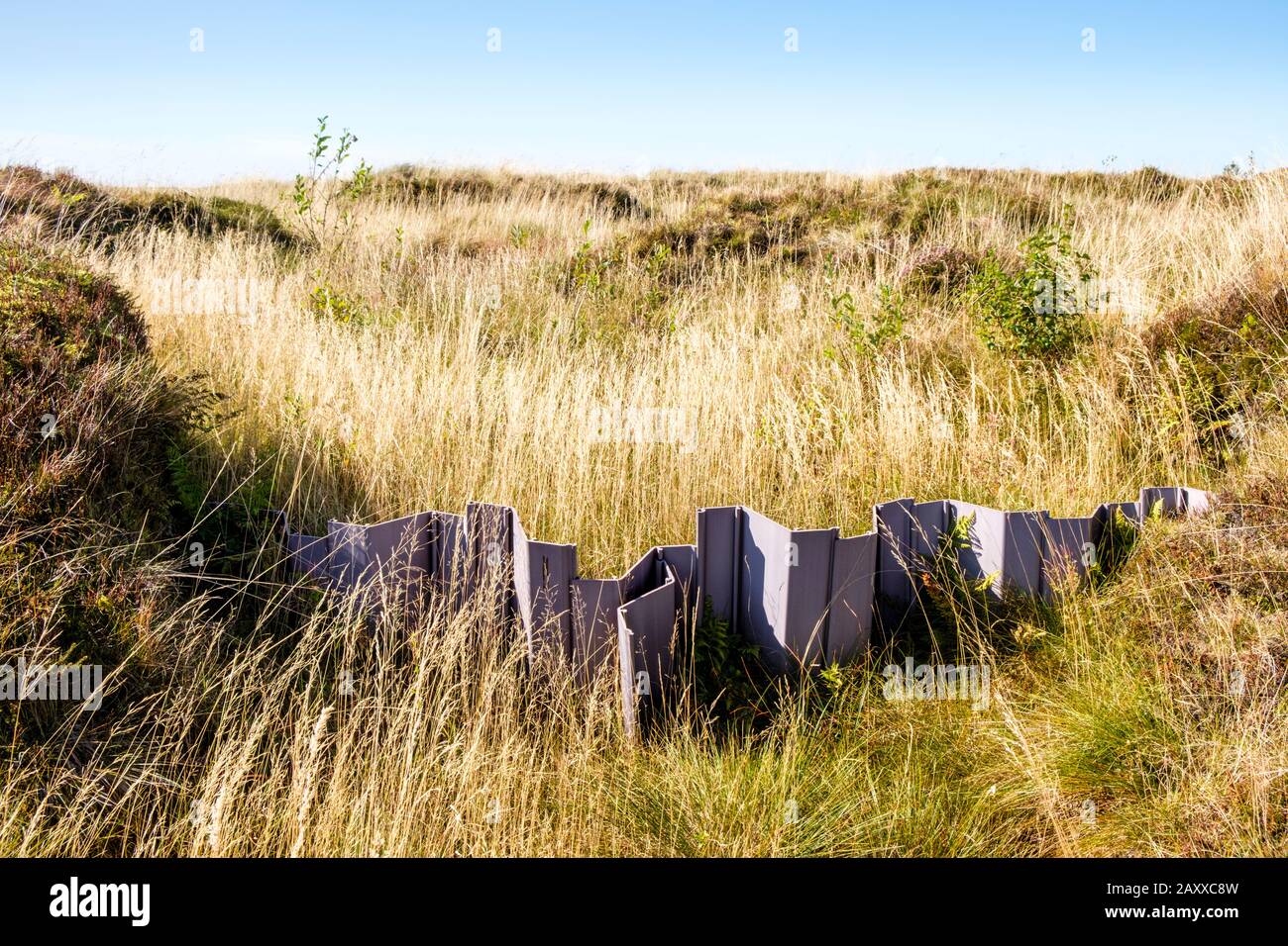 A plastic dam used to block a gully in the restoration of a moor ...