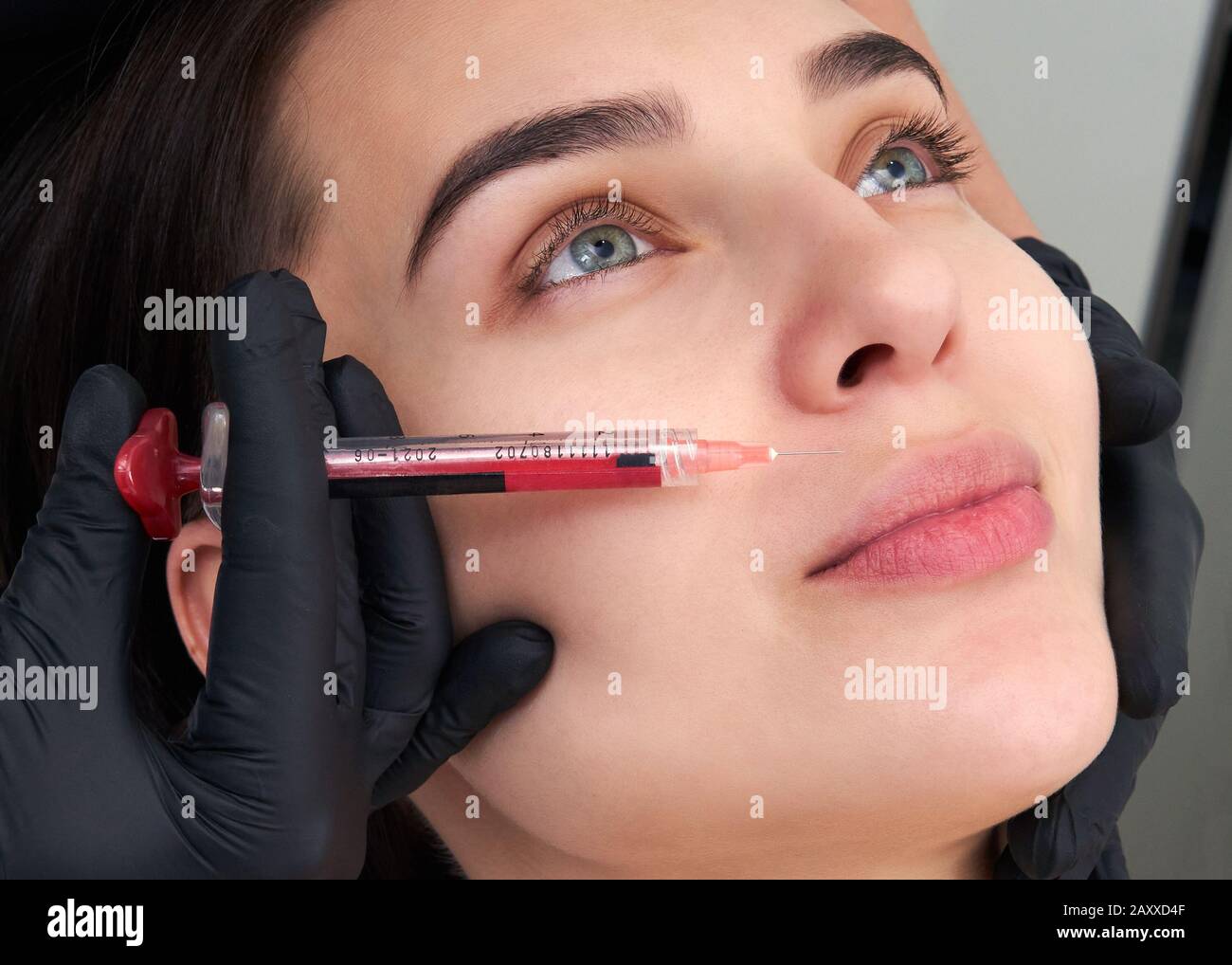 Beautiful woman gets an injection in lips Stock Photo - Alamy