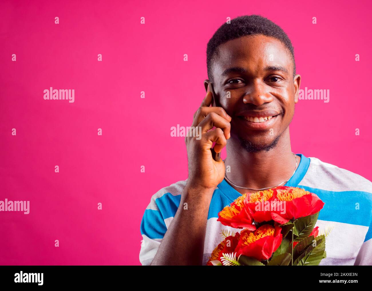 young african nigerian man isolated over pink background wearing strips ...
