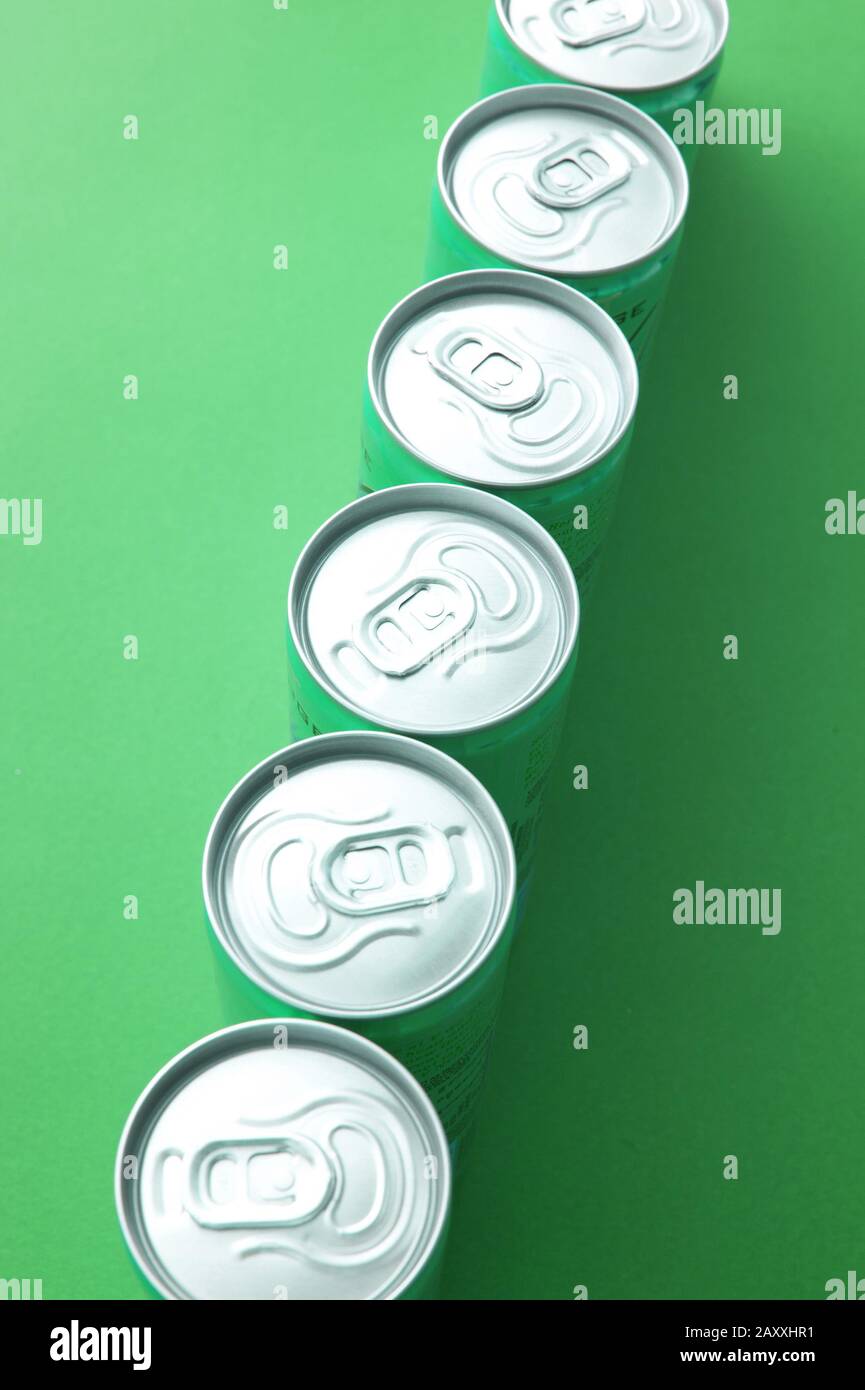 Cans of energy drink on green arranged in a receding diagonal line ...
