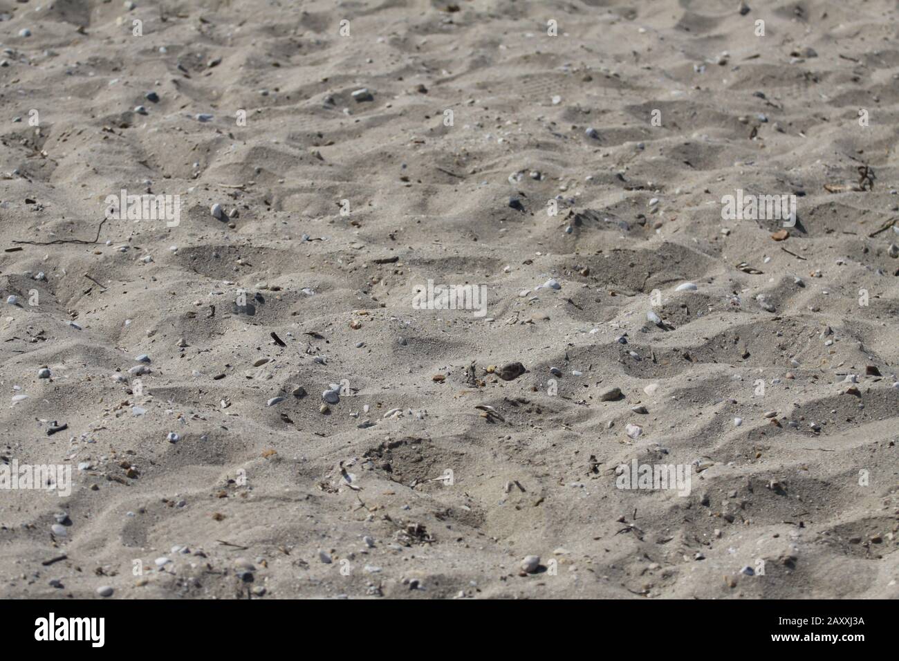 Sand with little pebbles on the beach Stock Photo - Alamy