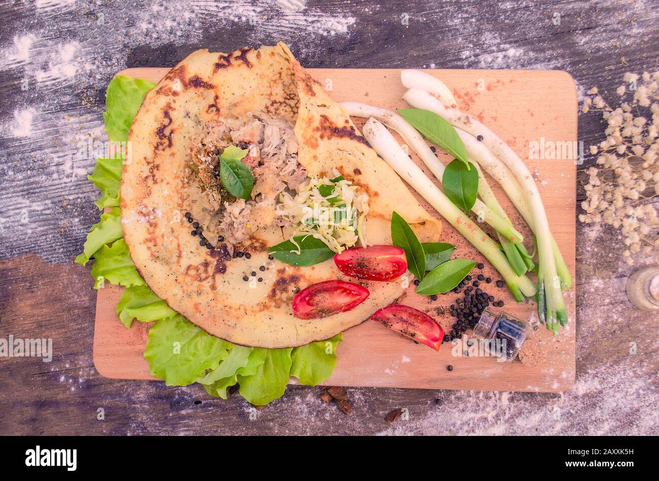 Shawarma in thin pita bread with chicken and vegetables on a wooden ...