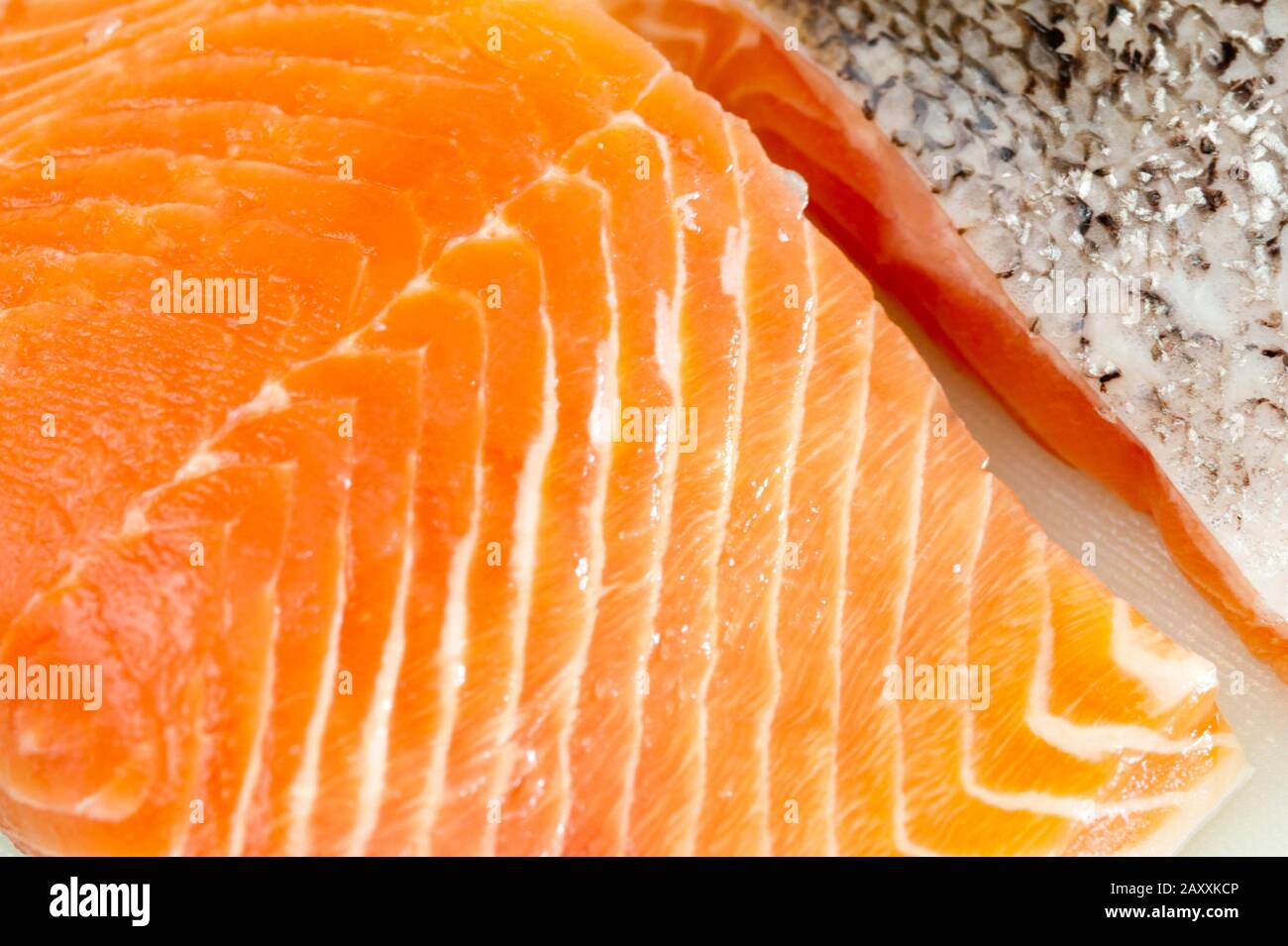 Close up texture of two filleted fresh salmon steaks, one with the ...
