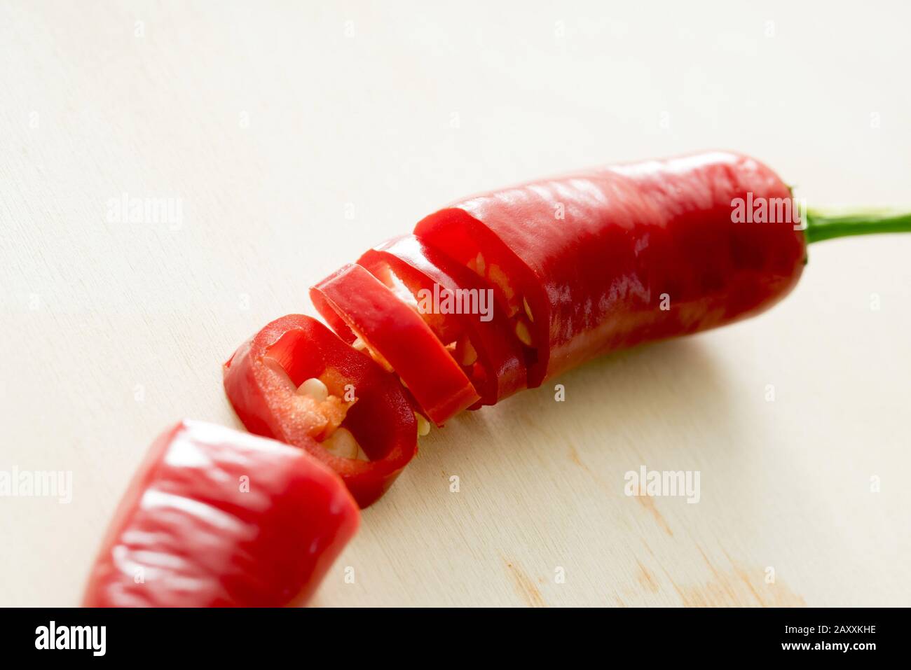 Sliced fresh spicy red hot chilli pepper pod in close up on a white ...